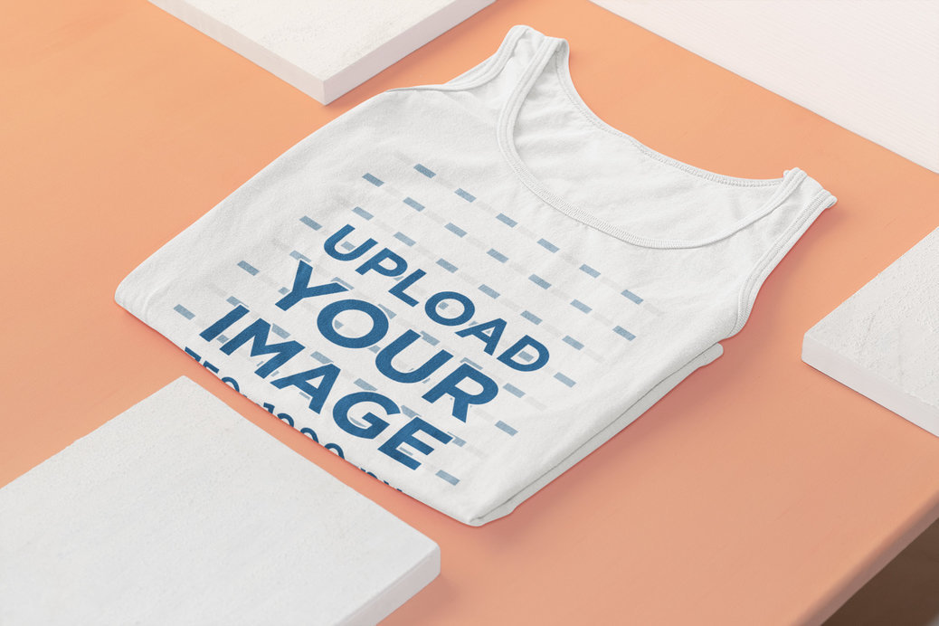 Placeit - Mockup of a Folded Tank Top Laid Flat on a Surface