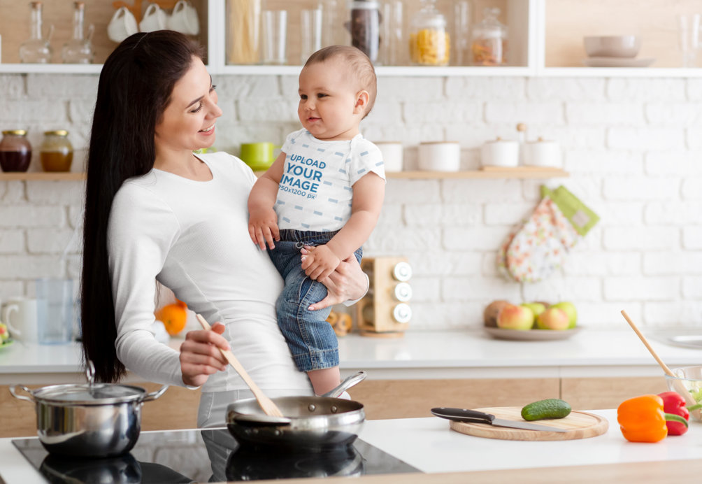 Placeit - Onesie Mockup of a Mom Holding His Baby While Cooking in Her ...