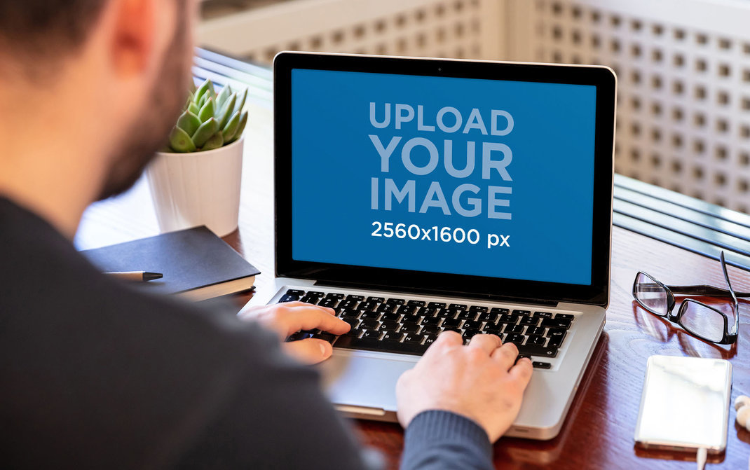 Placeit - MacBook Mockup of a Man Working from Home