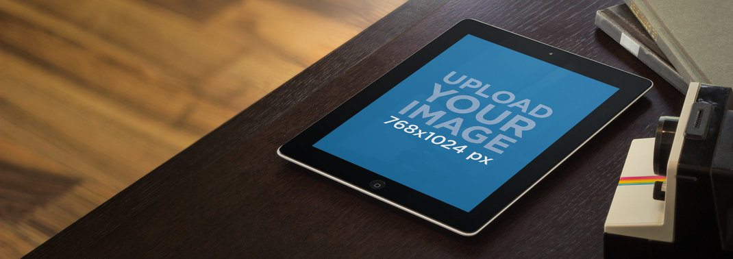 Placeit - Mockup of a Dark iPad Placed on a Wooden Desk