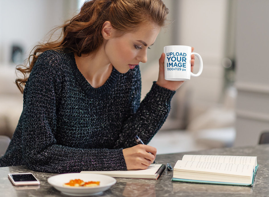 Placeit - 11 oz Coffee Mug Mockup of a Woman Taking Notes in the Kitchen