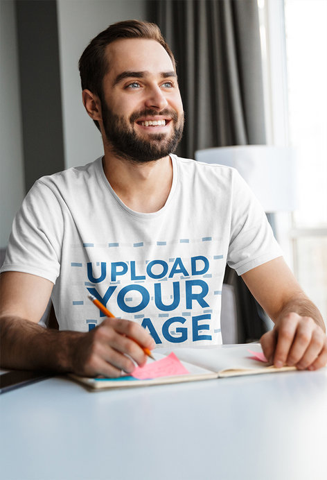 Placeit - T-Shirt Mockup of a Smiling Man Taking Notes
