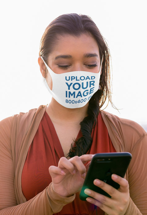Placeit - Mockup of a Woman with a Face Mask Checking Her Phone