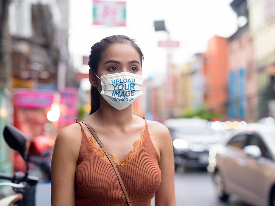 Placeit - Mockup of a Woman Wearing a Face Mask in a Street