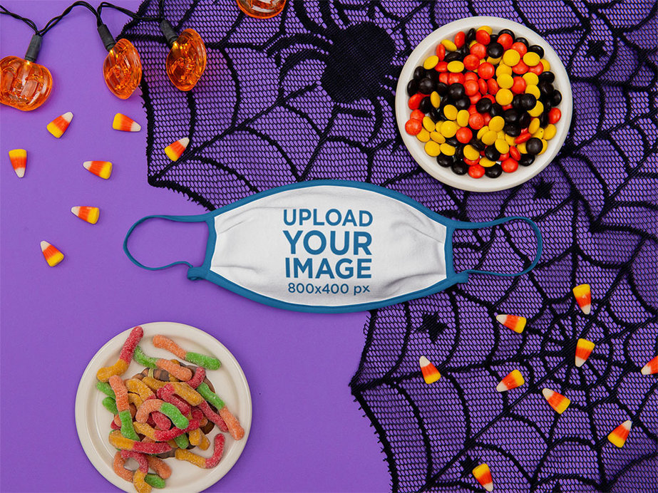 Placeit - Mockup of a Face Mask Surrounded by Halloween Candy