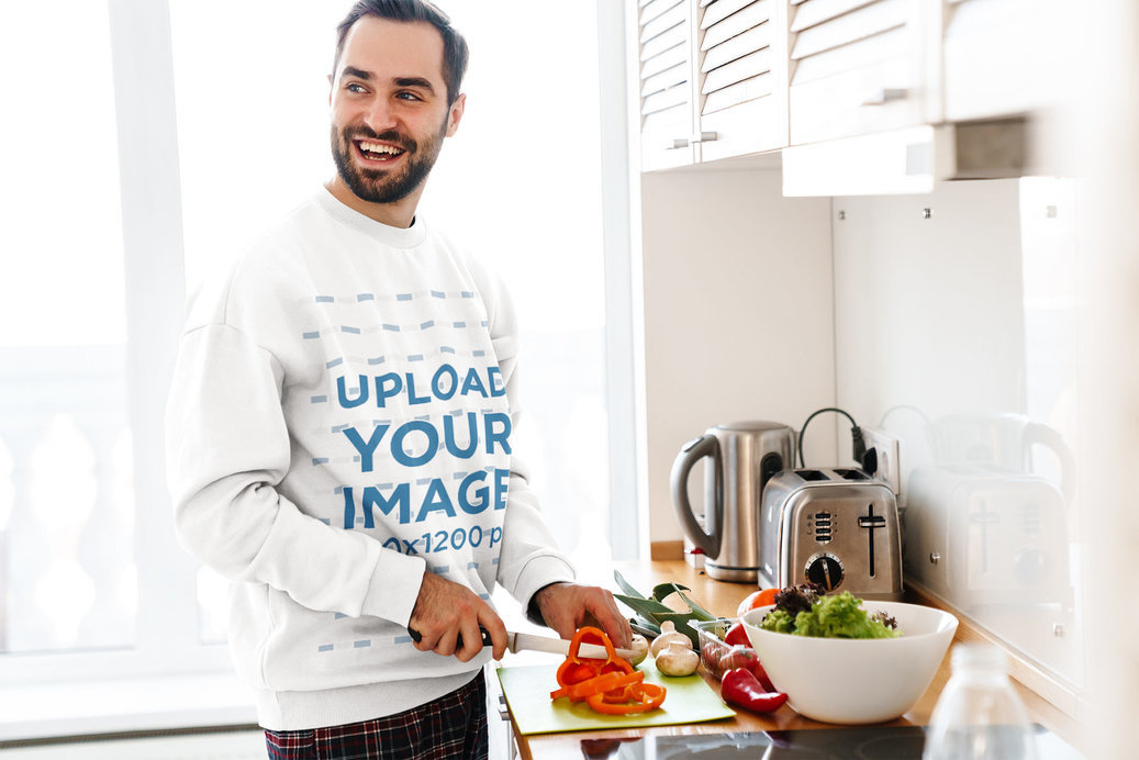 Placeit - Sweatshirt Mockup Featuring a Happy Man Cooking at Home
