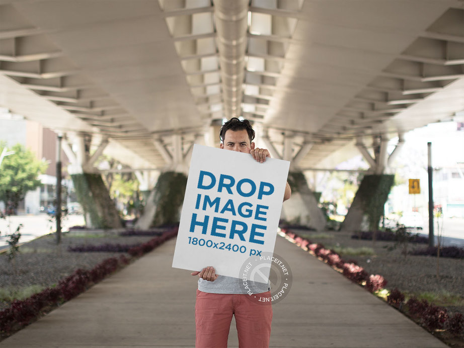 Placeit - Hipster Dude Holding a Big Poster While Below a Beautiful ...