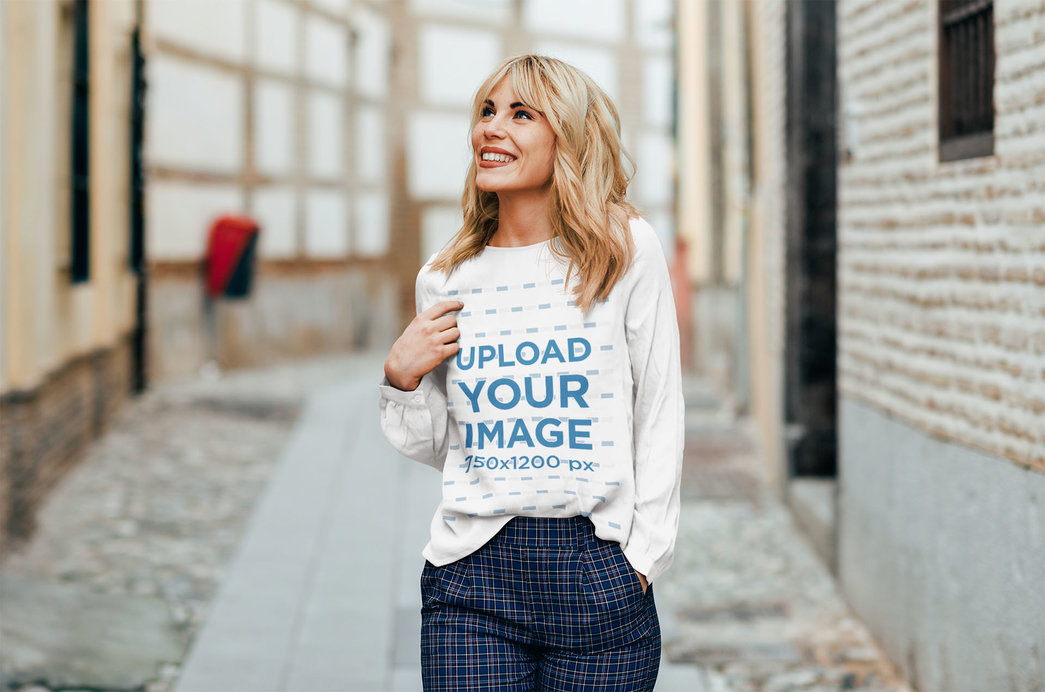 Placeit - Long-Sleeve Tee Mockup Featuring a Woman Walking on a Tiny Street
