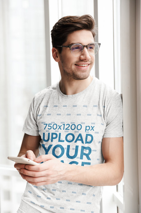 Placeit - T-Shirt Mockup of a Man Texting by a Window