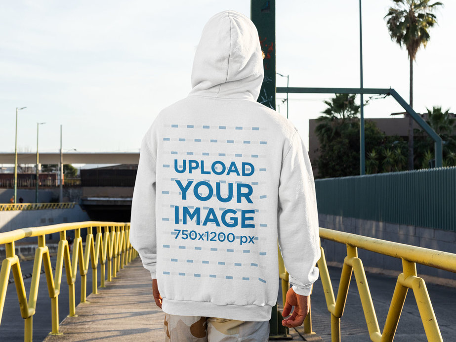Placeit - Back-View Hoodie Mockup of a Man Standing on a City Street