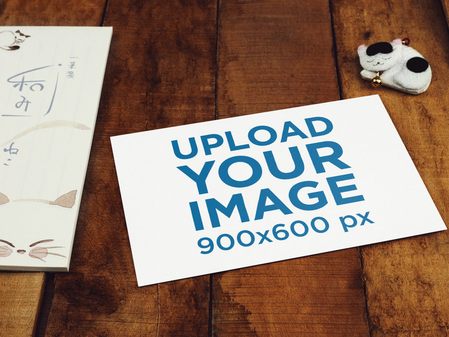 Placeit - Postcard Template Lying on a Wooden Table Near a Kitten Nearby