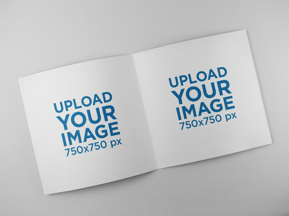 Placeit - Square Booklet Mockup Open Lying on a Solid Surface