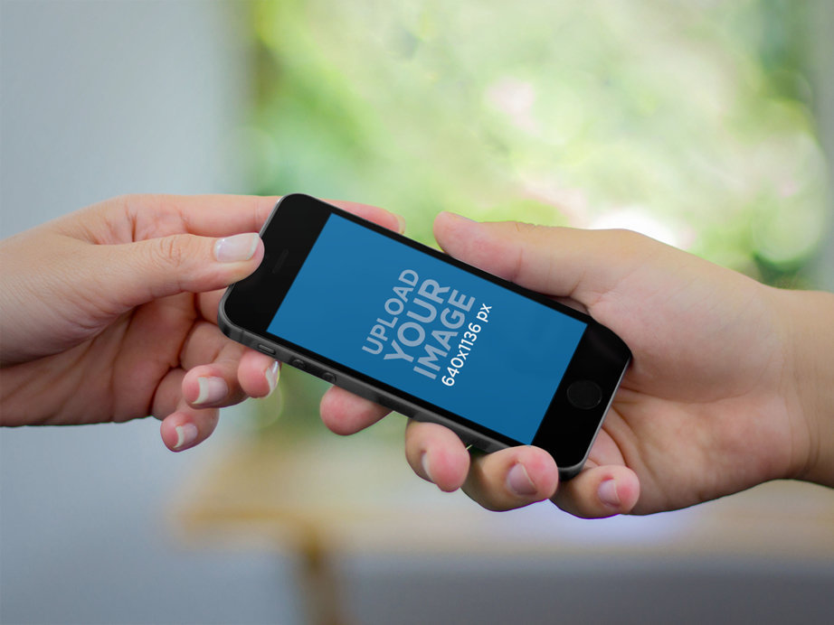 Placeit - Mockup of Two People Holding a Space Grey iPhone 5s