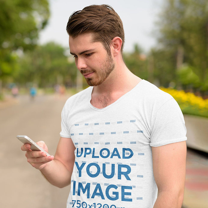 Placeit - Heathered Tee Mockup of a Man Looking at His Mobile Phone